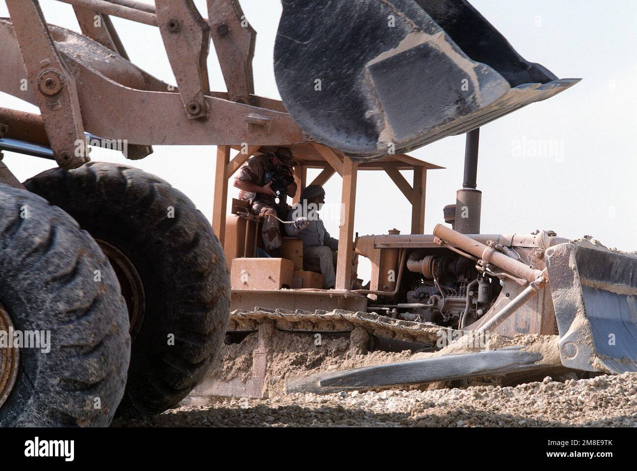 Photographer's Mate 2nd Class Milton Savage sits behind the civilian ...