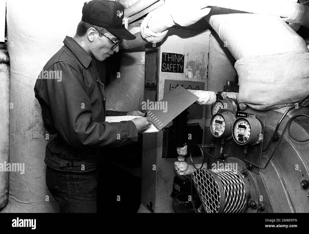 A crew member records gauge readings in the boiler room of the ocean ...