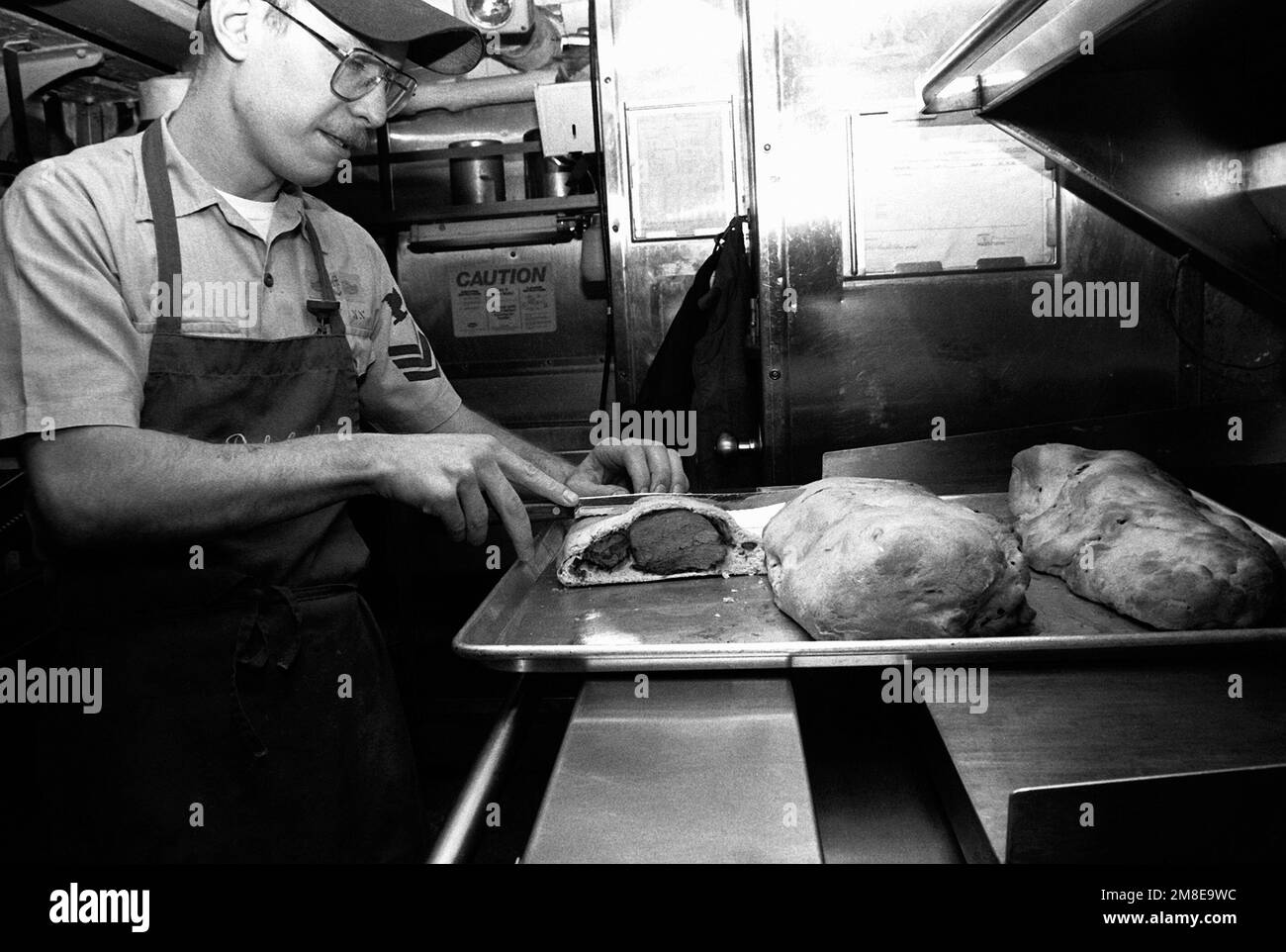 A mess management specialist prepares a meal aboard the ocean ...