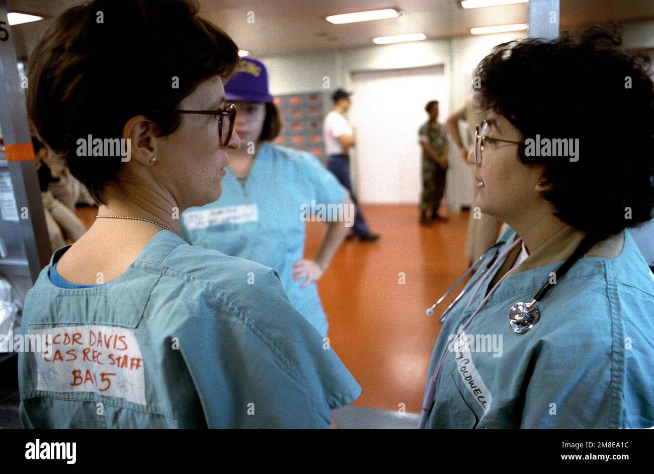 Medical personnel converse aboard the hospital ship USNS COMFORT (T-AH ...