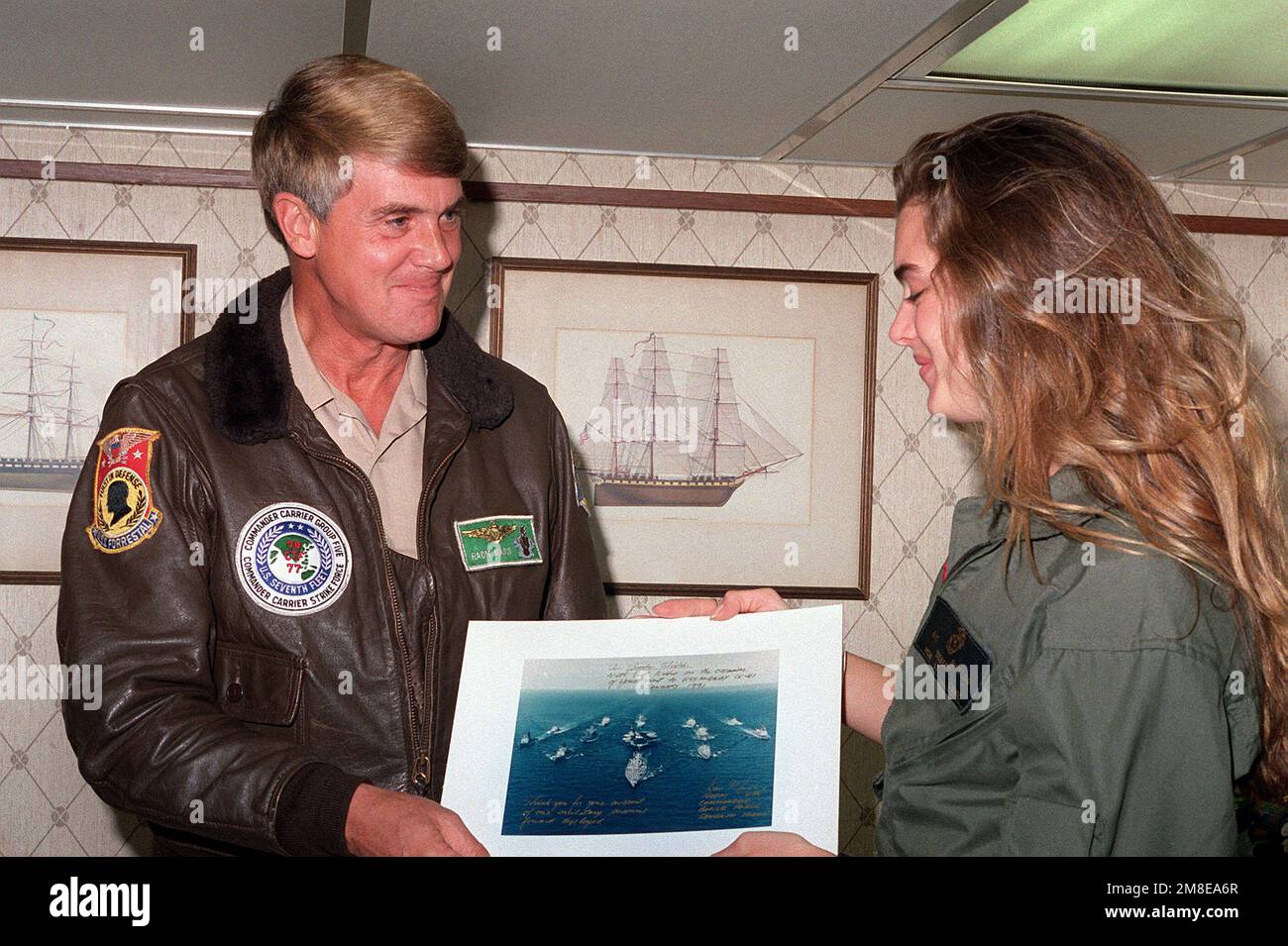 Rear Adm. Daniel P. March, commander, Carrier Group Five, presents a ...