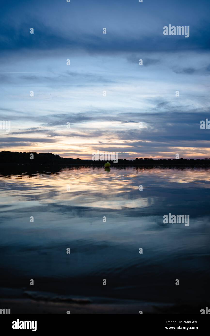 A vertical shot of a wonderful seascape with the reflection of sunset ...