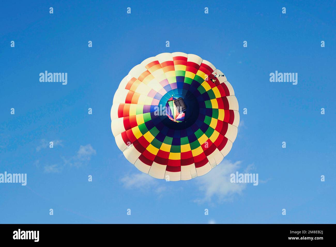 A colorful rainbow parachute in the bright clear sky straight from ...