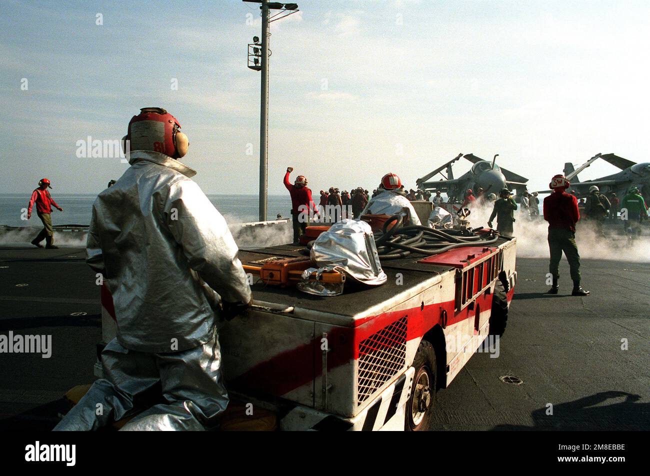 Two crash and rescue crew members man a P-16 shipboard firefighting and ...