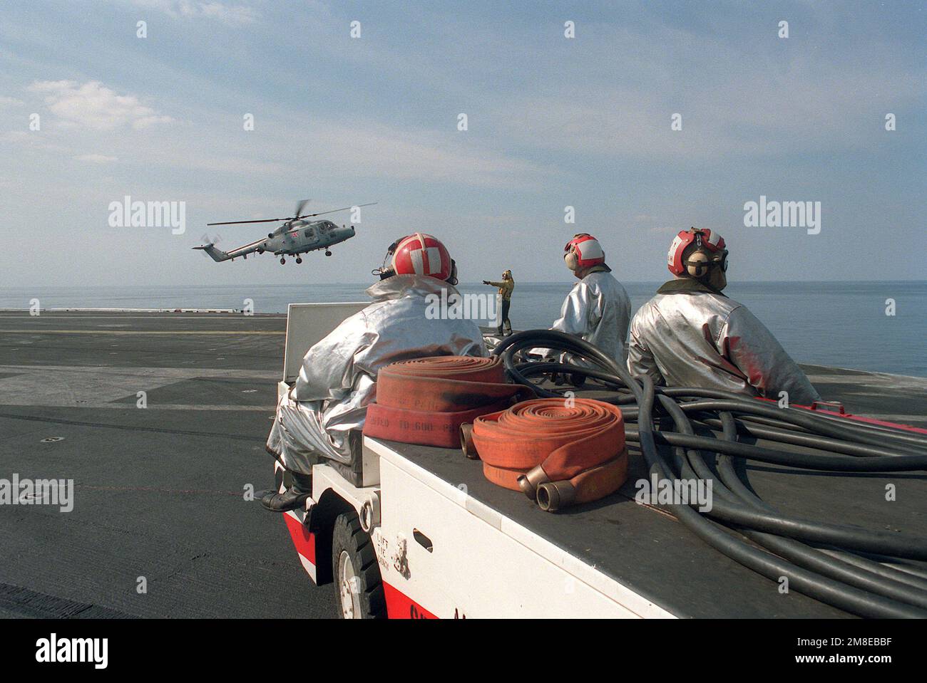 Crash and rescue crew members man a P-16 shipboard firefighting and ...