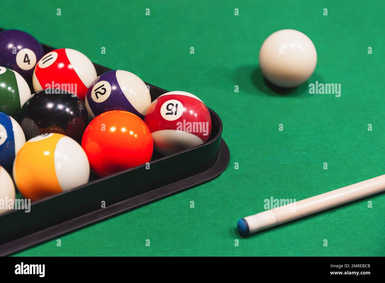 Colorful billiard balls with numbers with cue sticks and rack on green ...
