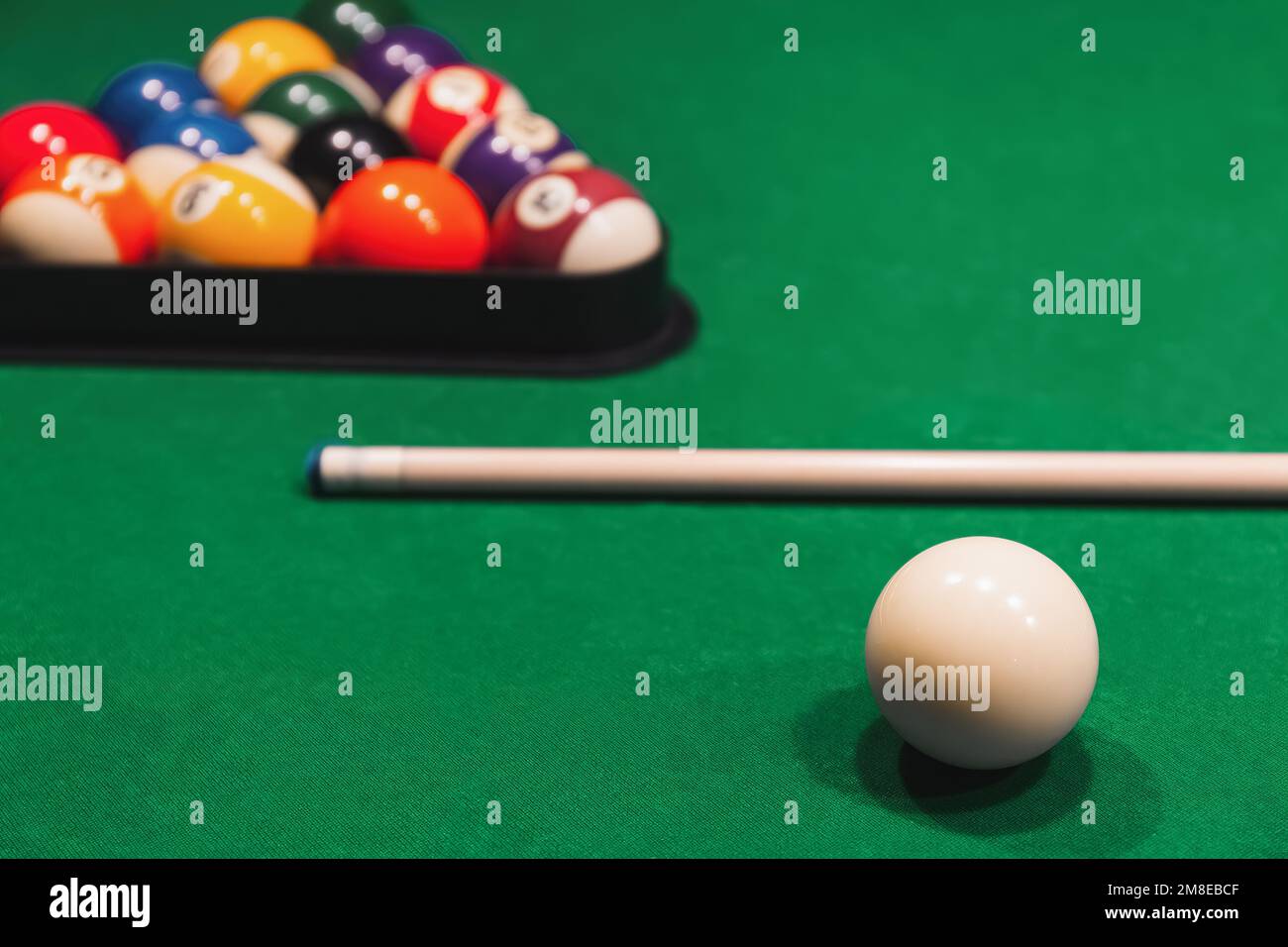 Colorful billiard balls with numbers with cue sticks and rack on green ...
