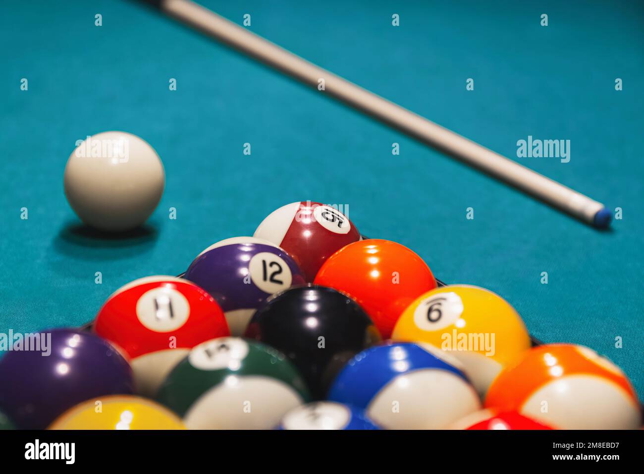 Colorful billiard balls with numbers with cue sticks and rack on blue ...