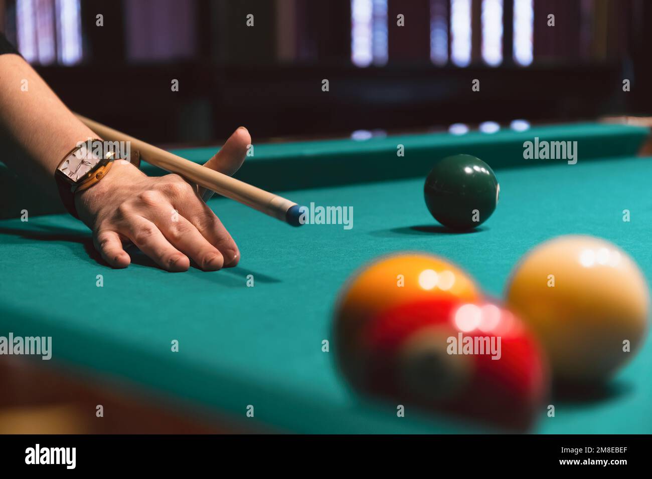 Player holding que and aiming to billiard white ball. White ball on ...
