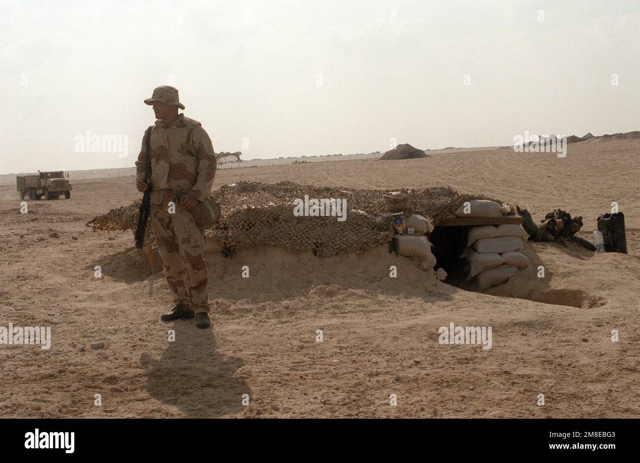 A Marine stands in front of a sandbag bunker in the 3rd Marine Regiment ...