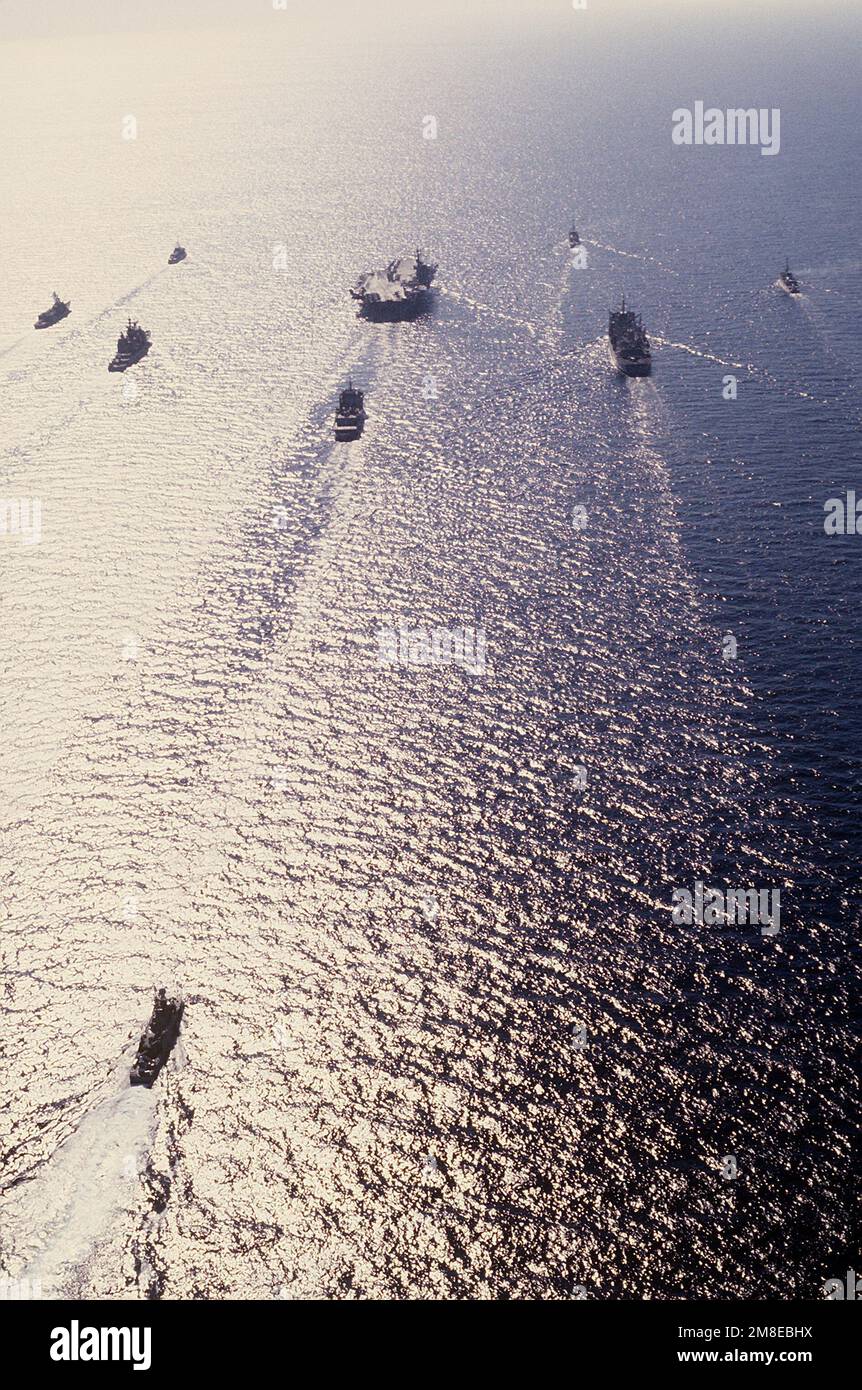 An aerial stern view of nine ships of Battle Force Red Sea underway ...