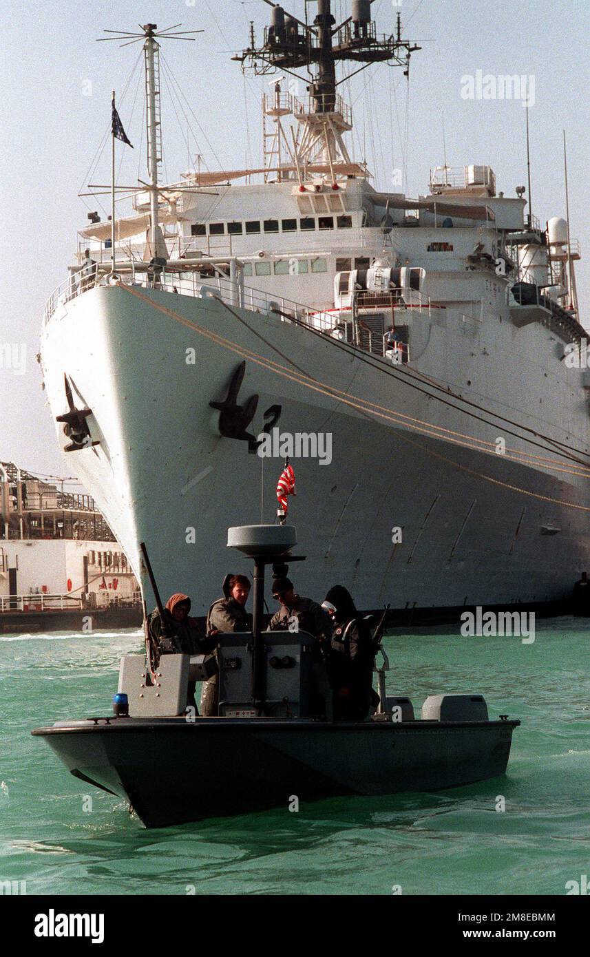 Coast Guard security personnel in a Sea Raider utility craft pass the ...