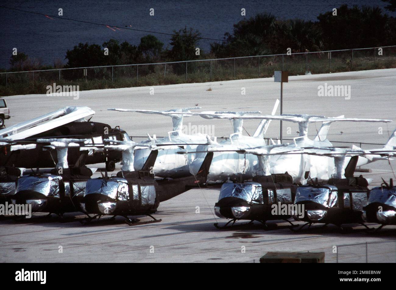UH-1H Iroquois helicopters, some covered with protective wrappings, and ...