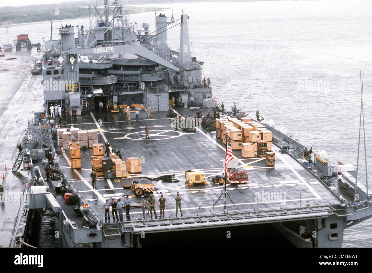 Marines and sailors wait on the flight deck of the amphibious transport ...