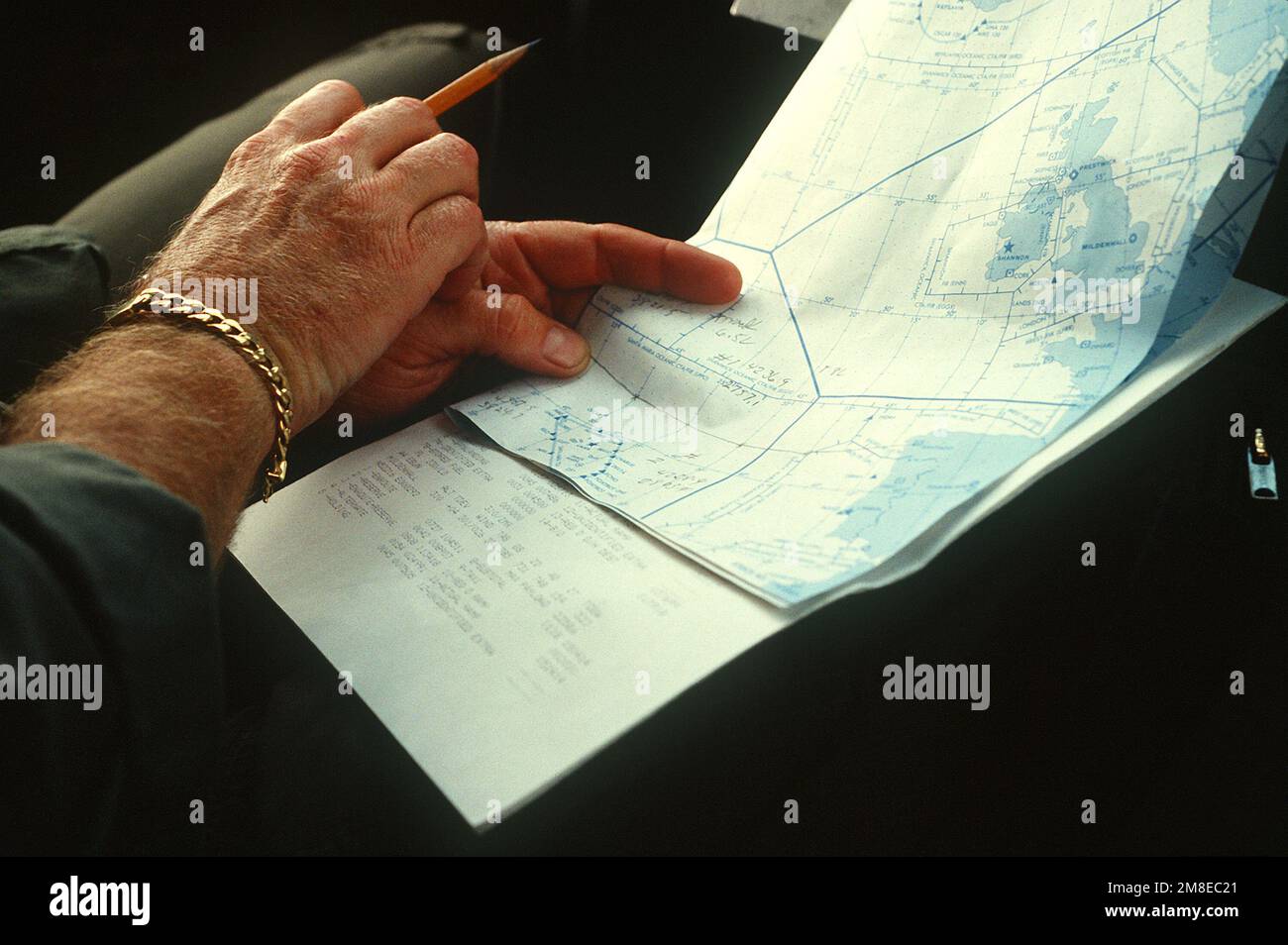 The co-pilot of a transport aircraft checks an aeronautical chart ...