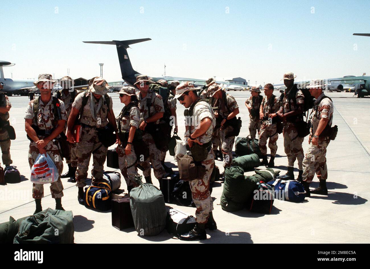 U.S. Air Force personnel stand by with their baggage shortly after ...