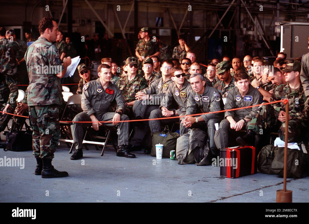 An airman calls the names of personnel waiting at a processing point as ...