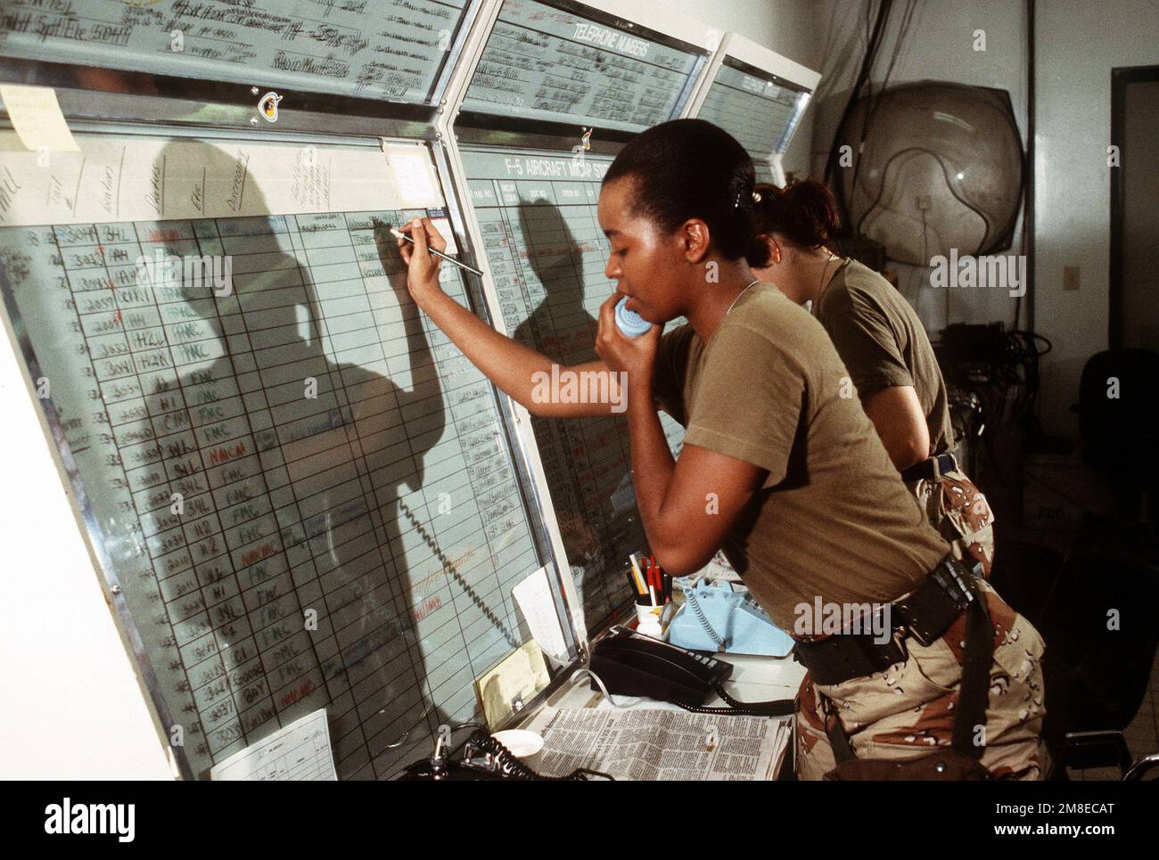 An airman updates a status board in an aircraft maintenance control ...