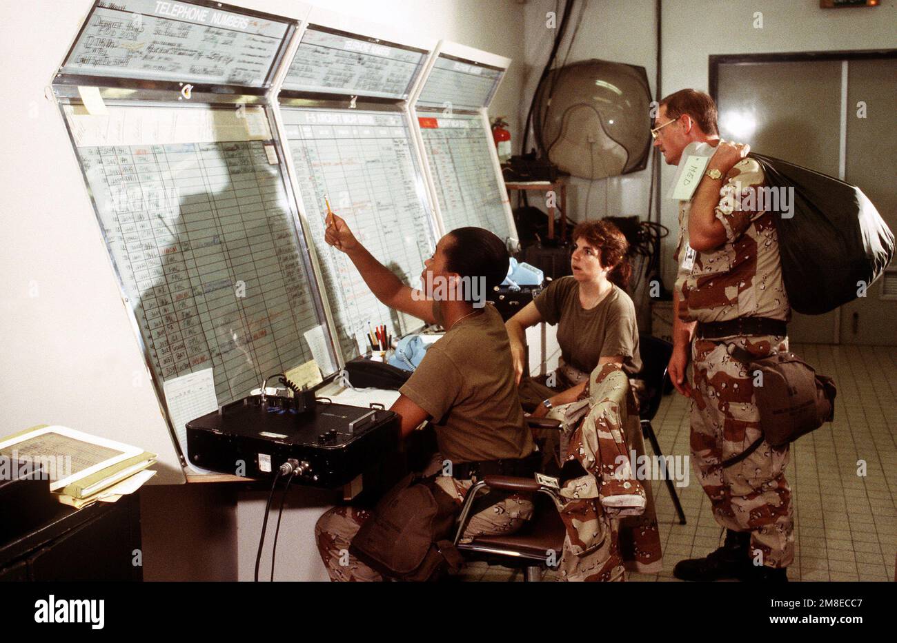 An officer receives an update from two airmen working in an aircraft ...