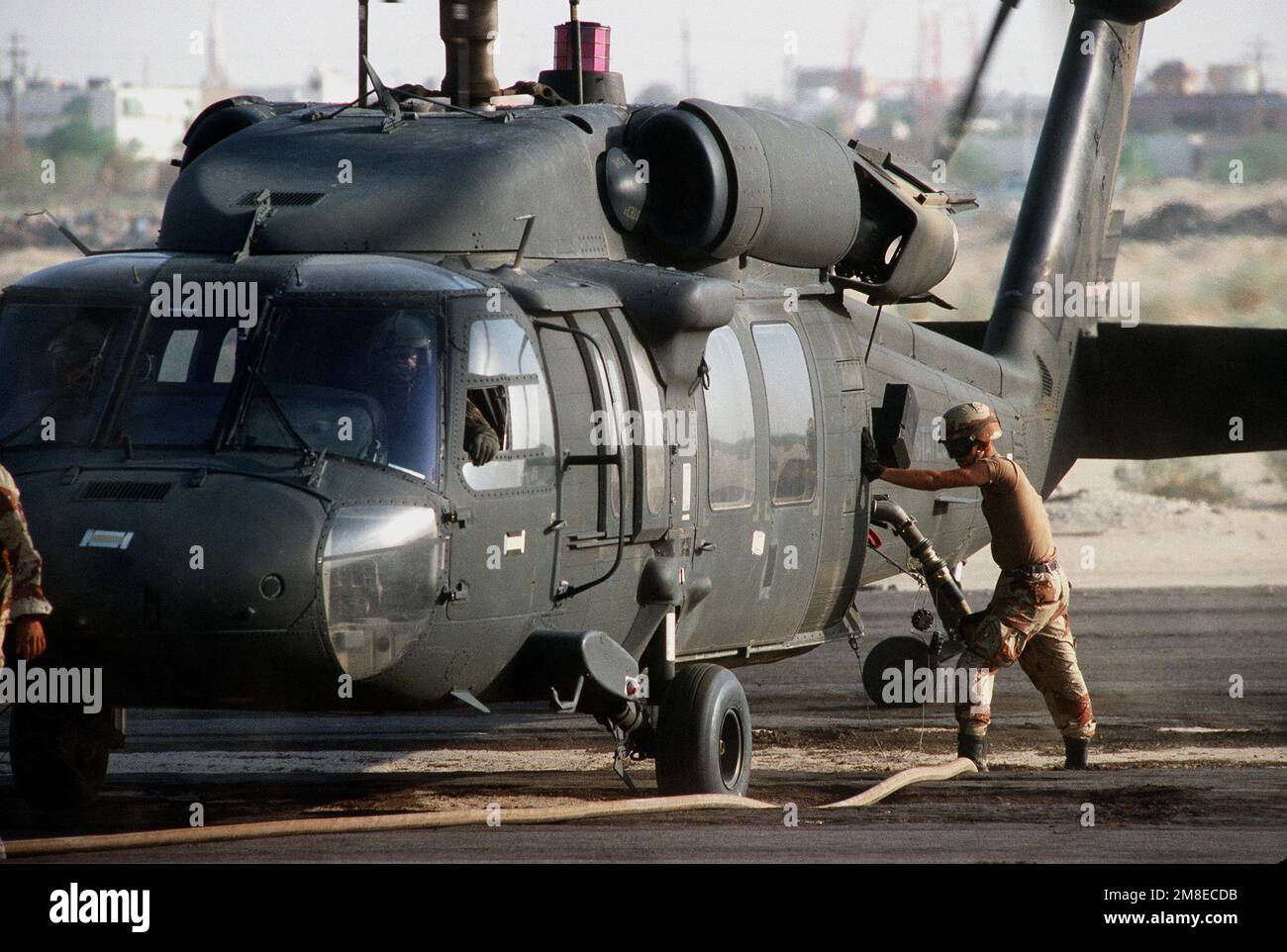 A soldier refuels a UH-60 Black Hawk (Blackhawk) helicopter during ...