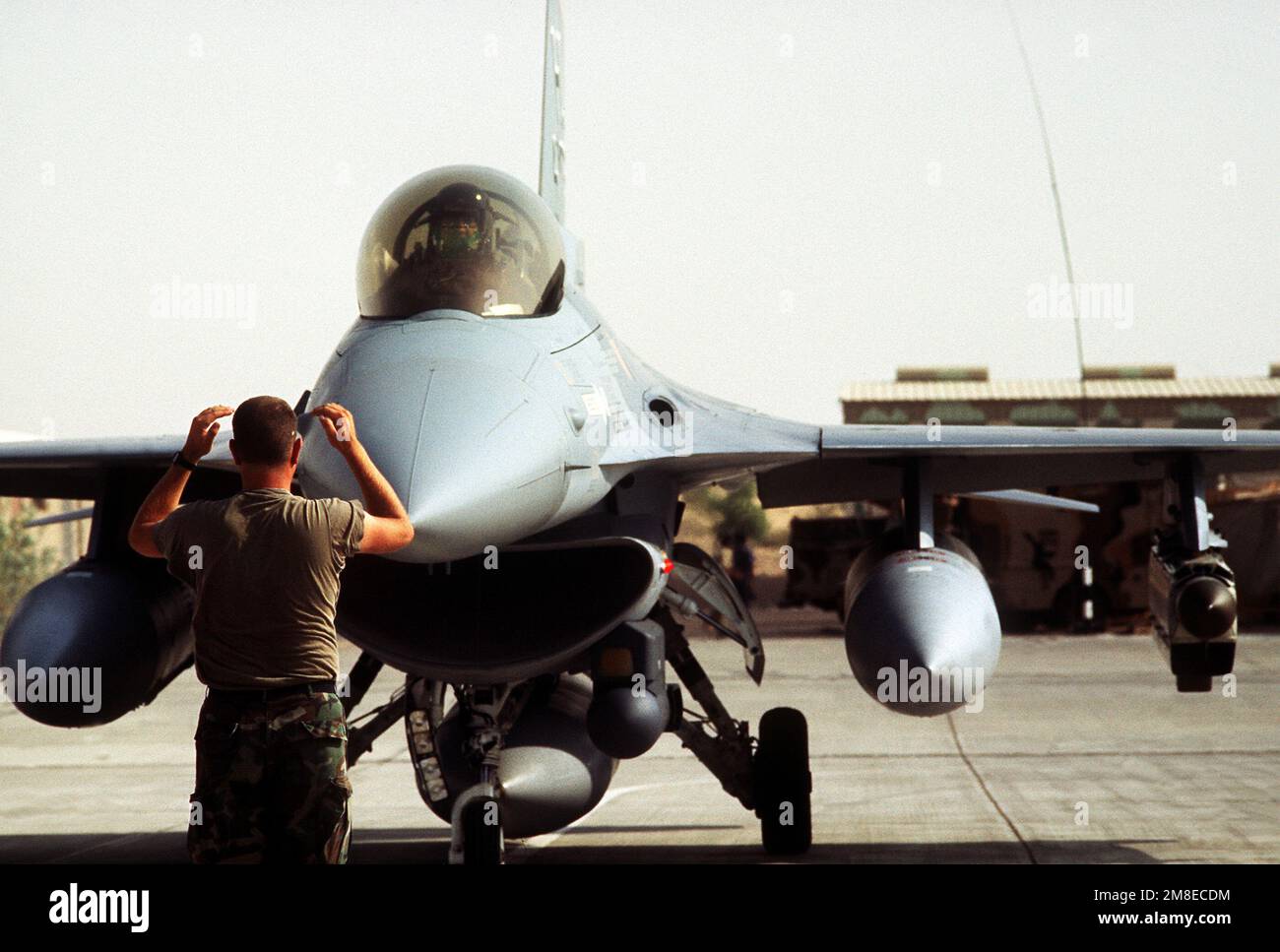 A ground crewman guides a 388th Tactical Fighter Wing (388th) F-16C ...