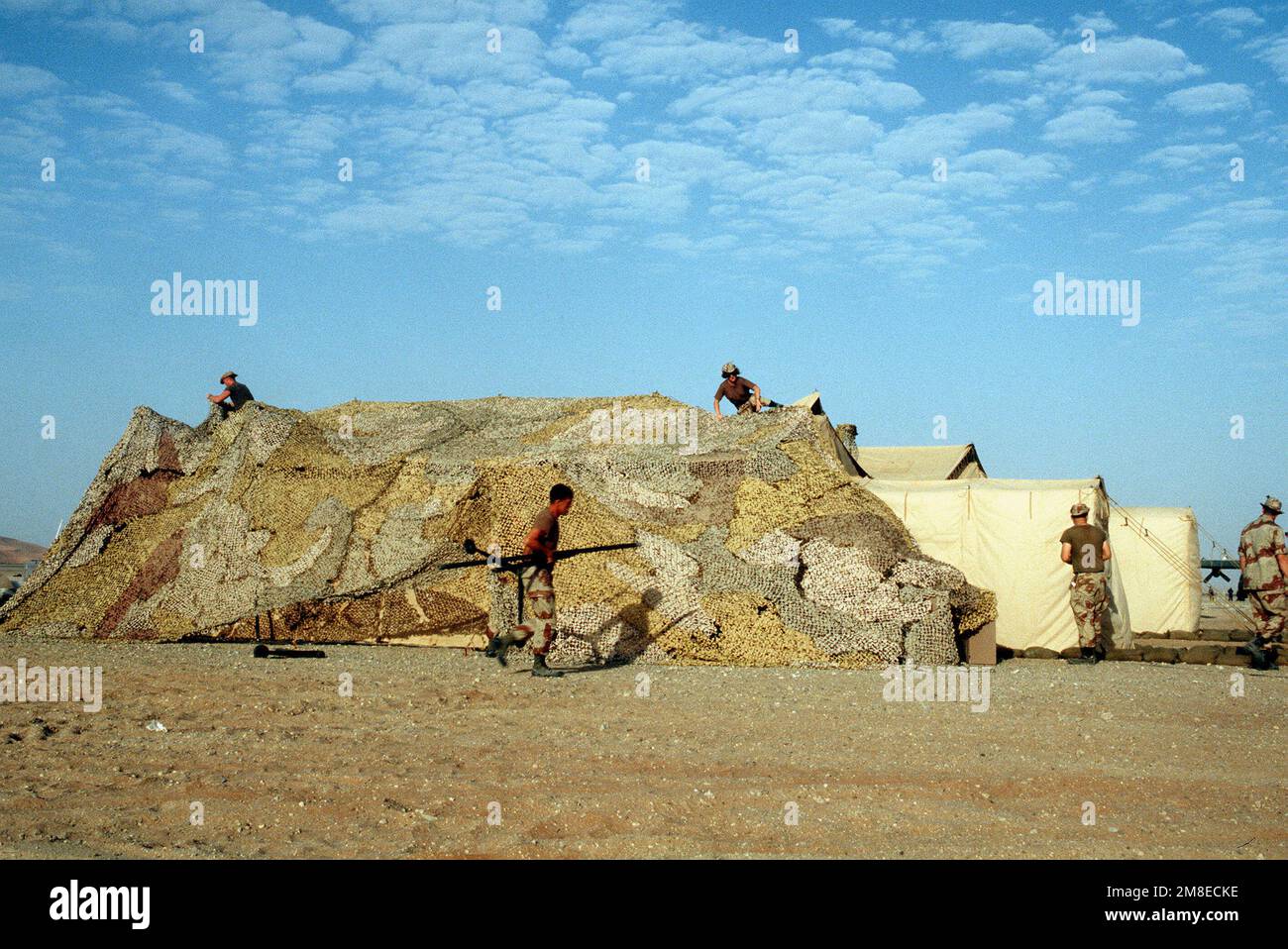 Members of the 3rd Combat Communications Group raise a large camouflage ...