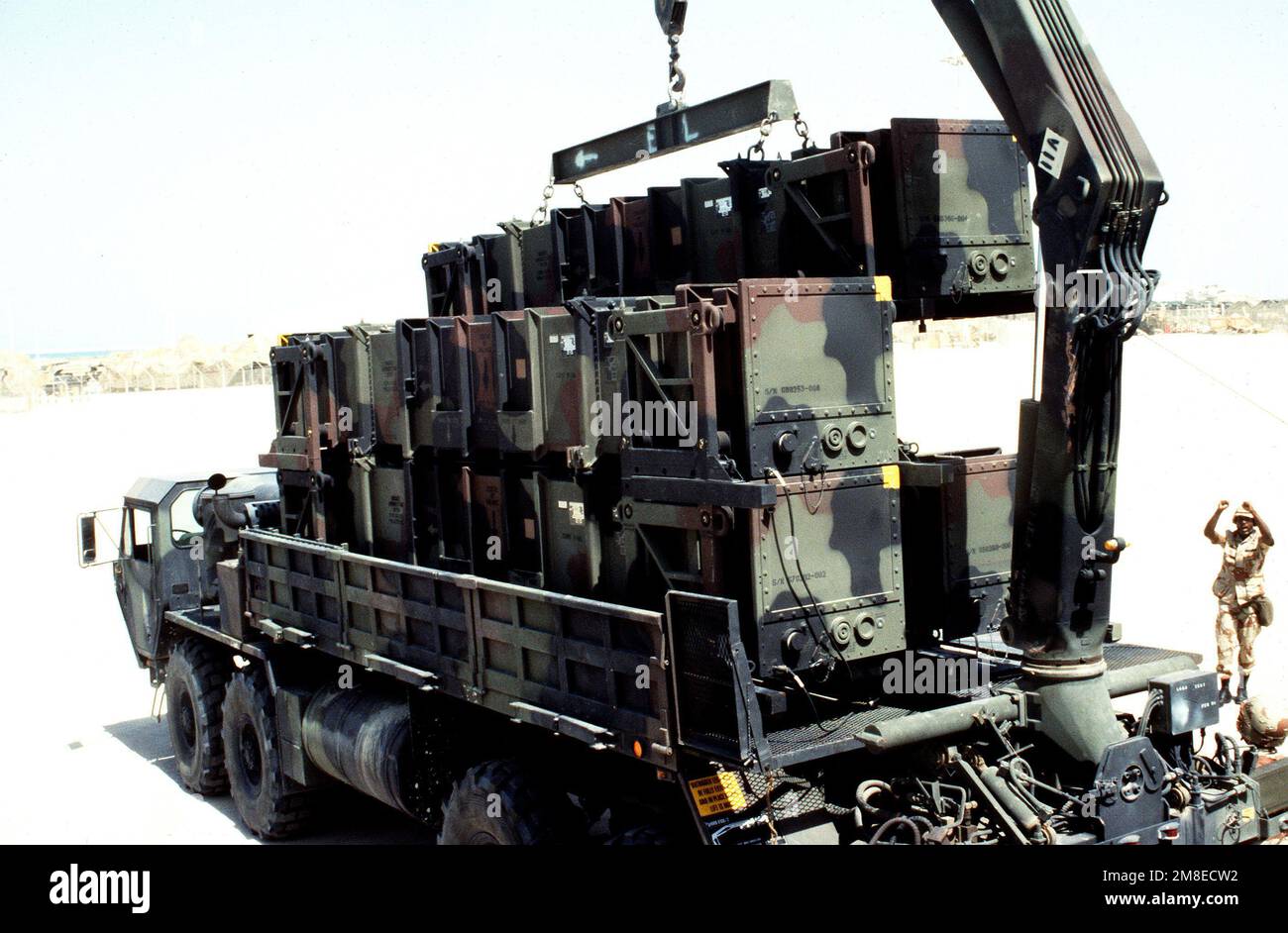 A crane is used to lift a canister containing a MIM-104 Patriot anti ...