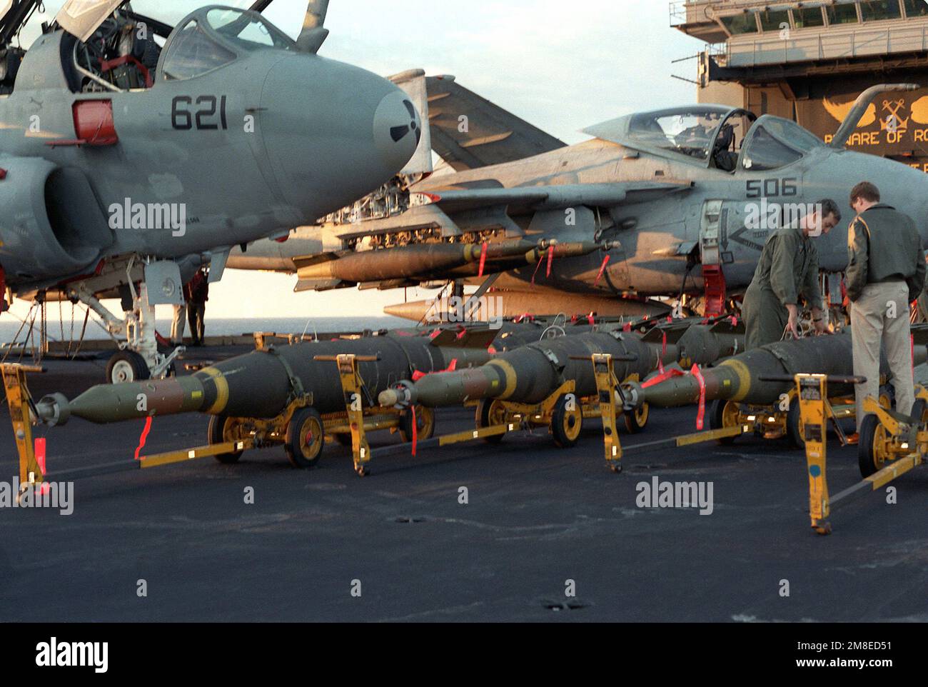 A pilot and an aviation ordnanceman inspect several GBU-10E/B Paveway ...