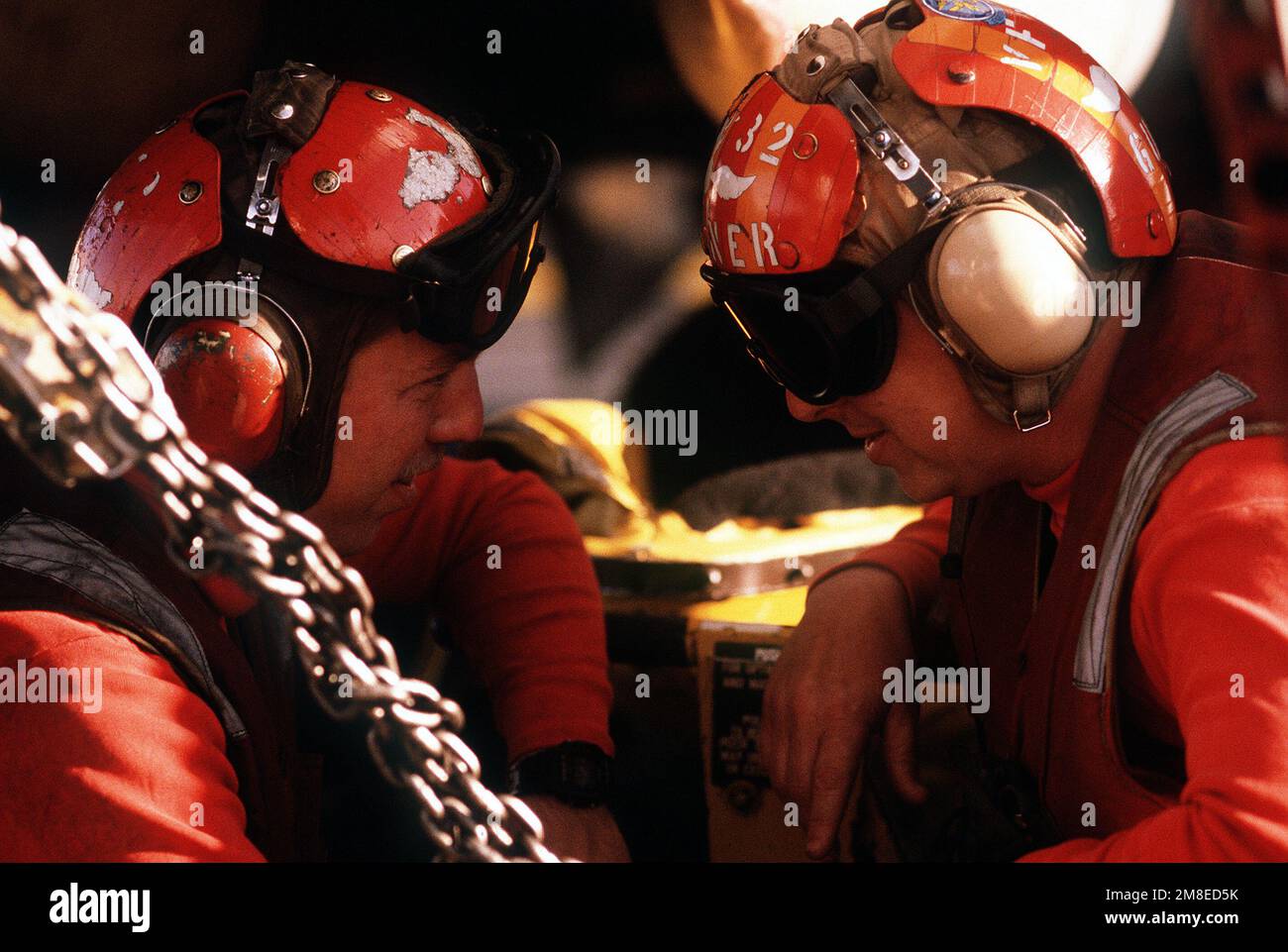 Aviation ordnancemen converse on the flight deck of the aircraft ...