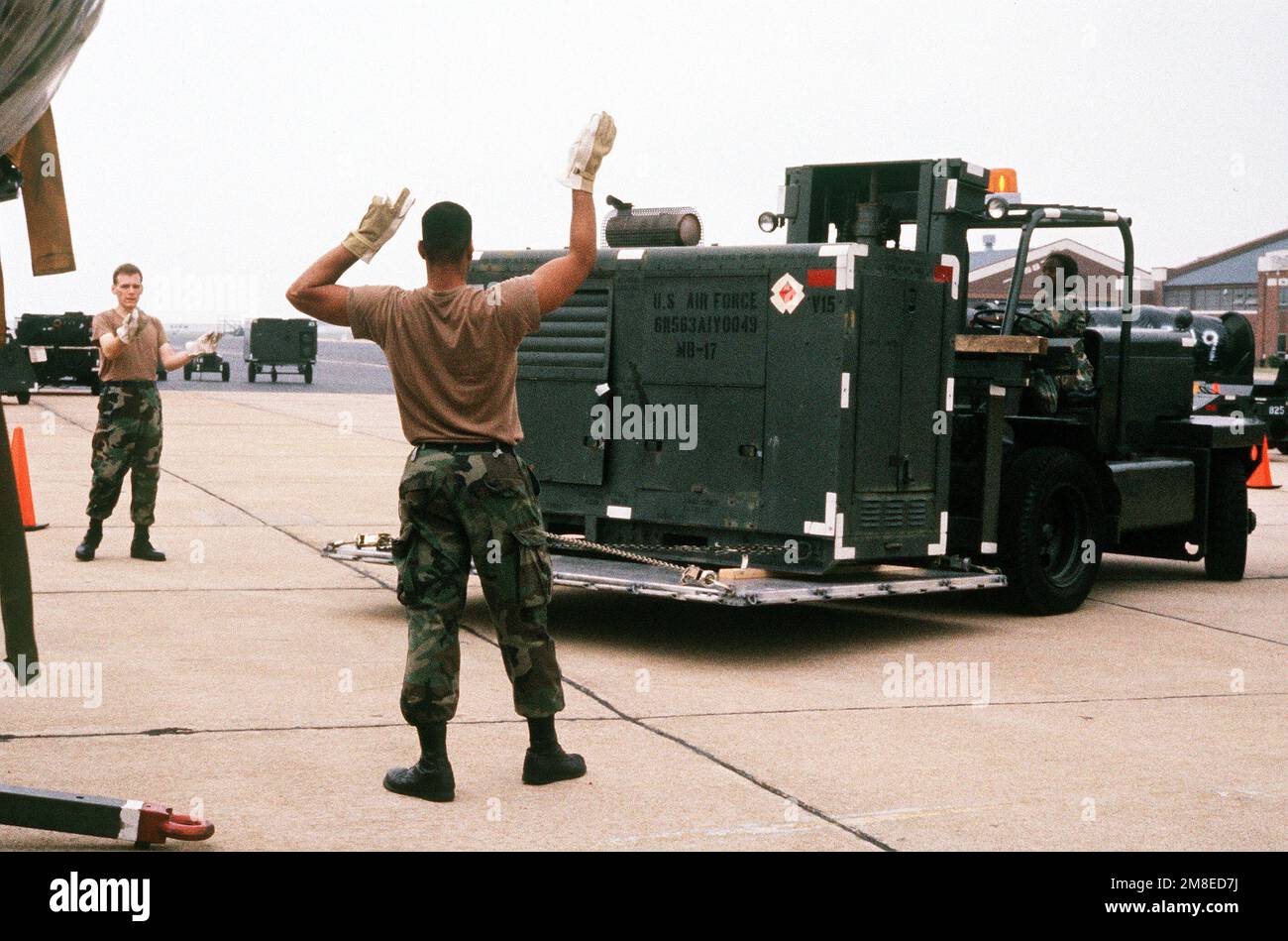 Ground crew members direct a forklift operator as she transports a ...