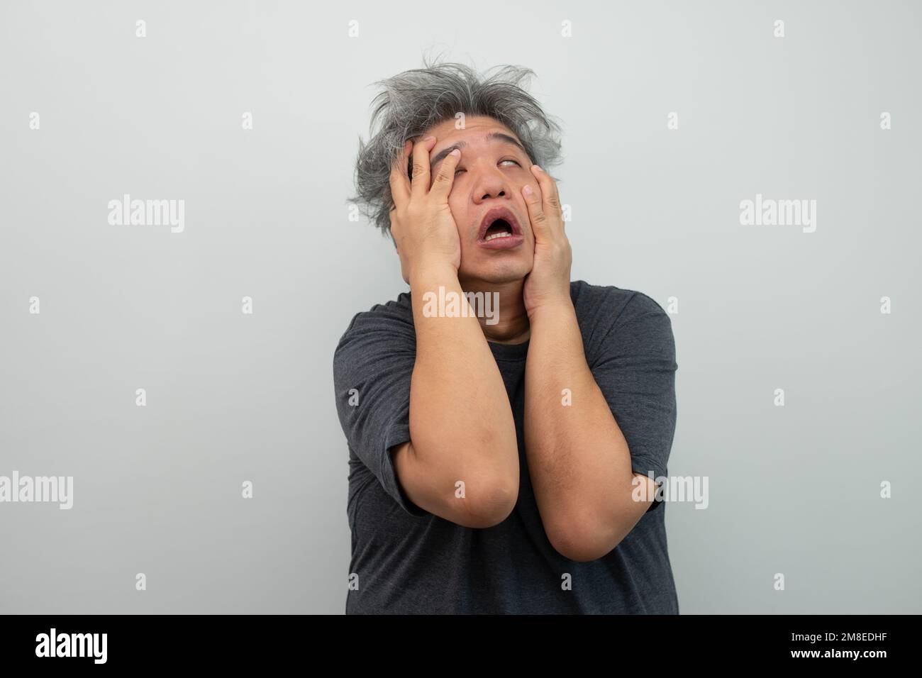 Portrait of a furious senior grey-haired man yelling and screaming and ...