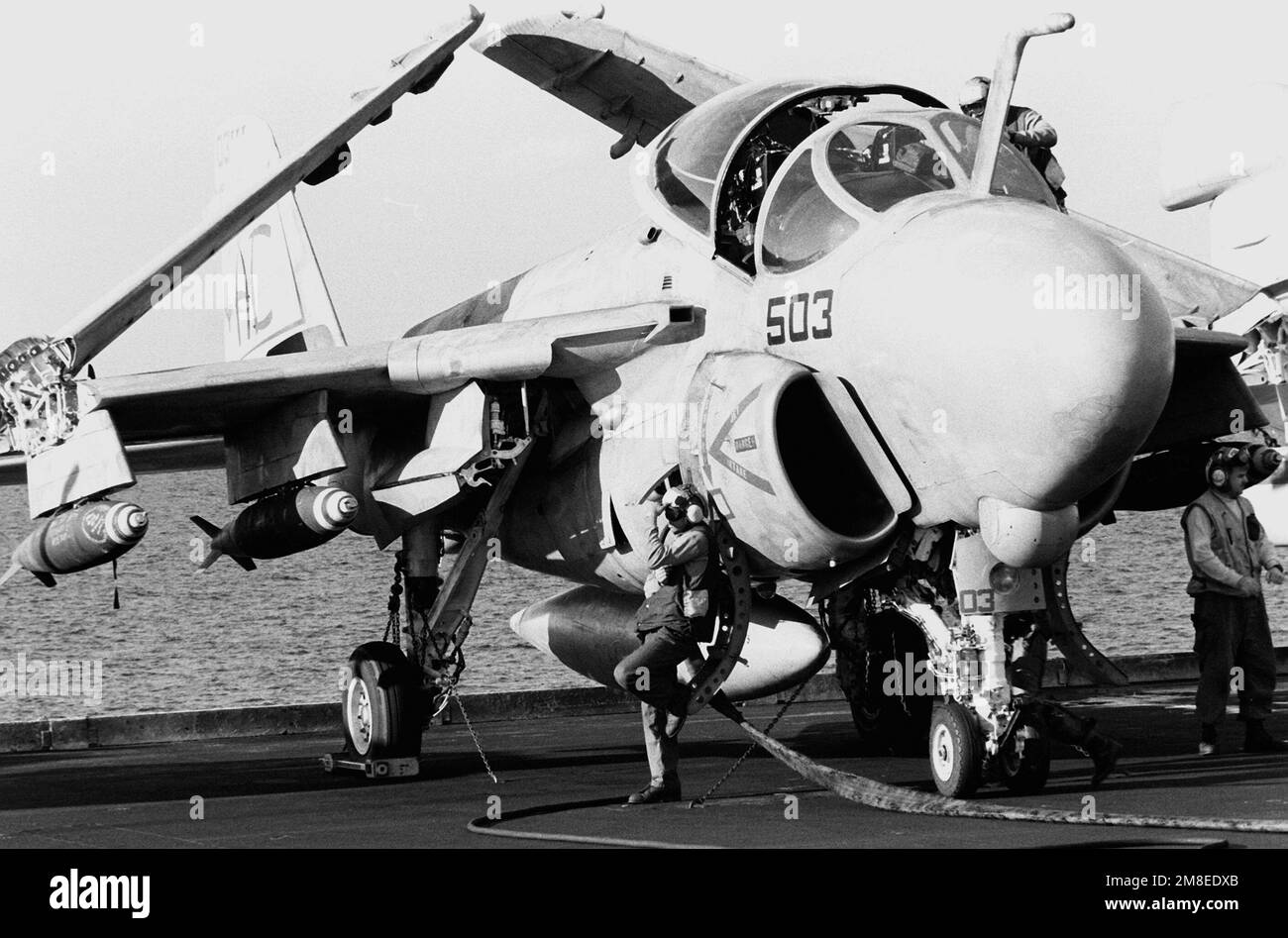 A flight deck crewman leans against an Attack Squadron 75 (VA-75) A-6E ...