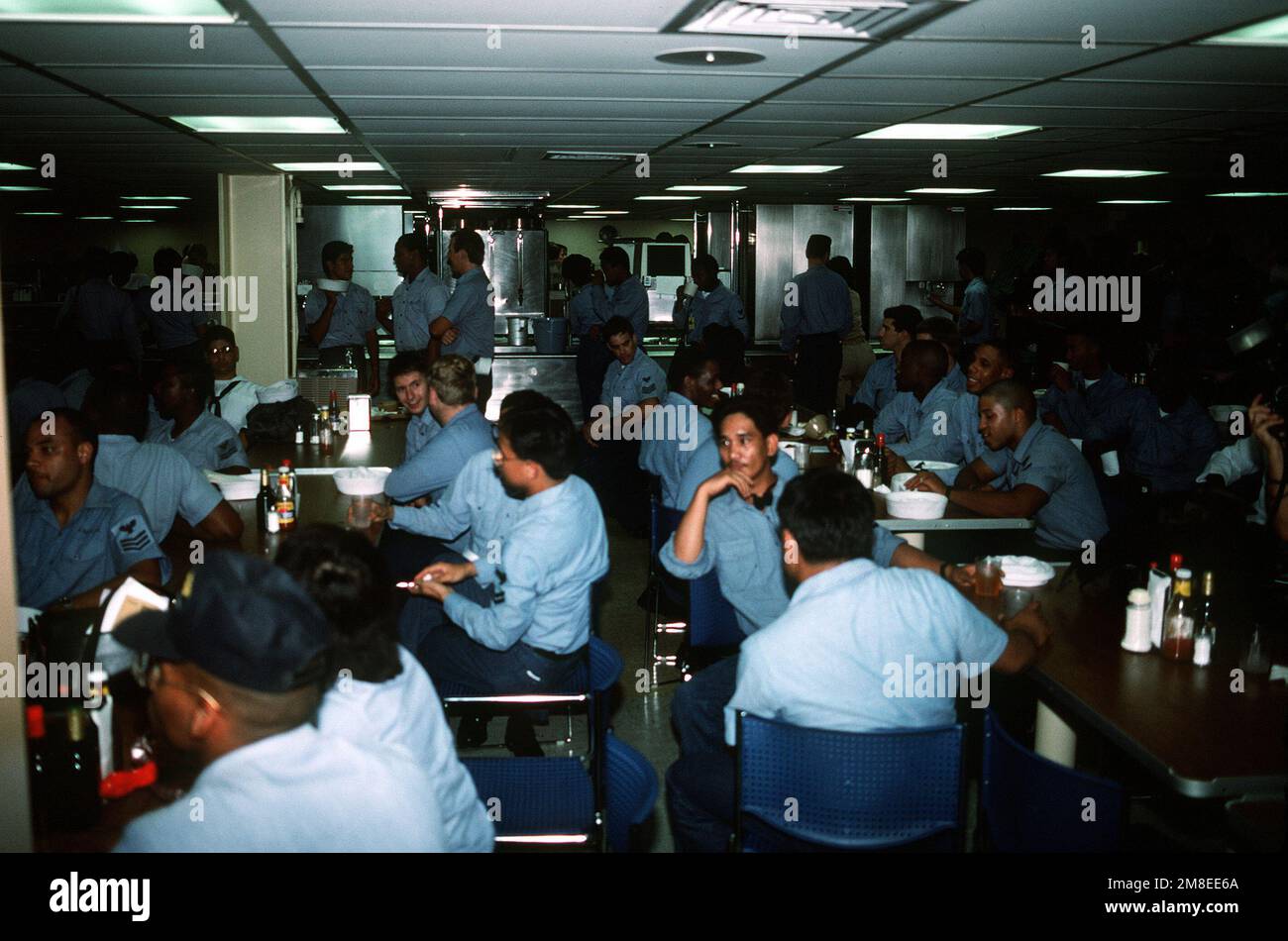 Crew members gather on the mess deck of the hospital ship USNS COMFORT ...