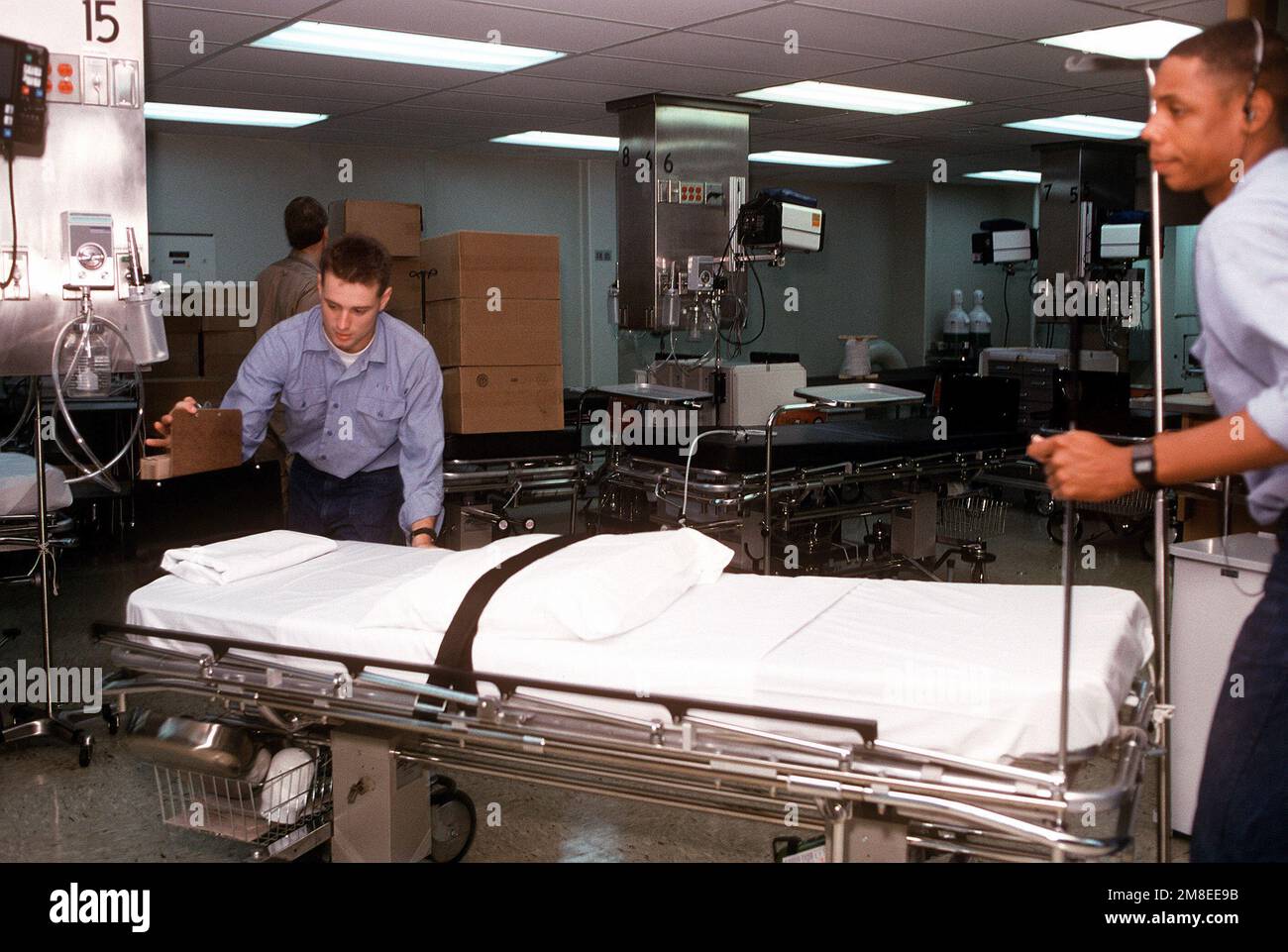 Crew members move a bed aboard the hospital ship USNS COMFORT (T-AH-20 ...