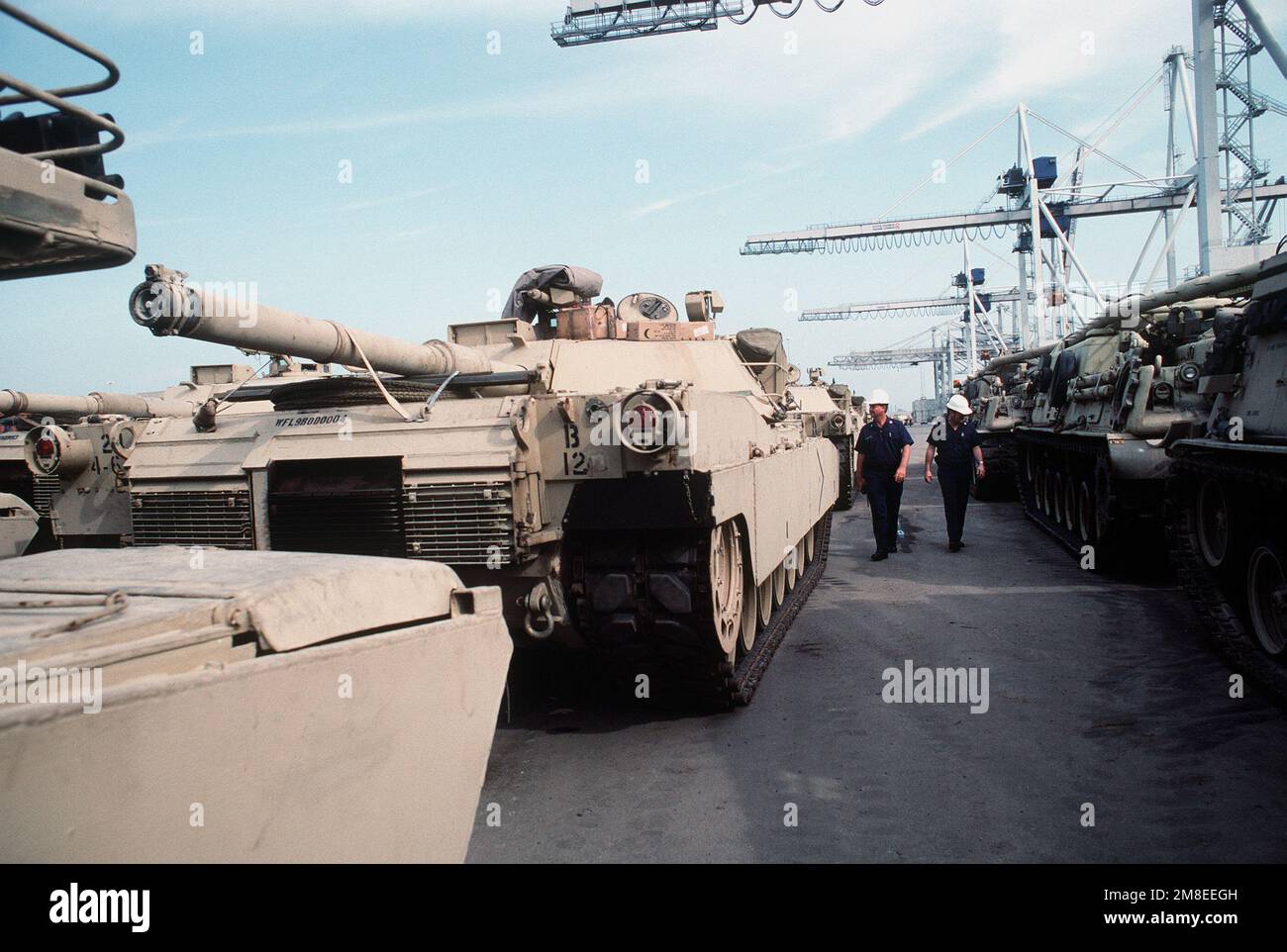 Workmen inspect M-1A Abrams tanks and M-88 armored recovery vehicles of ...