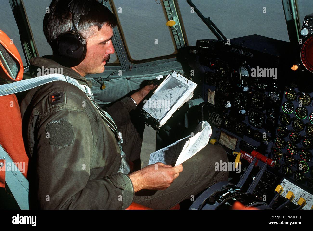 The pilot of a KC-135 Stratotanker aircraft consults a chart while on a ...
