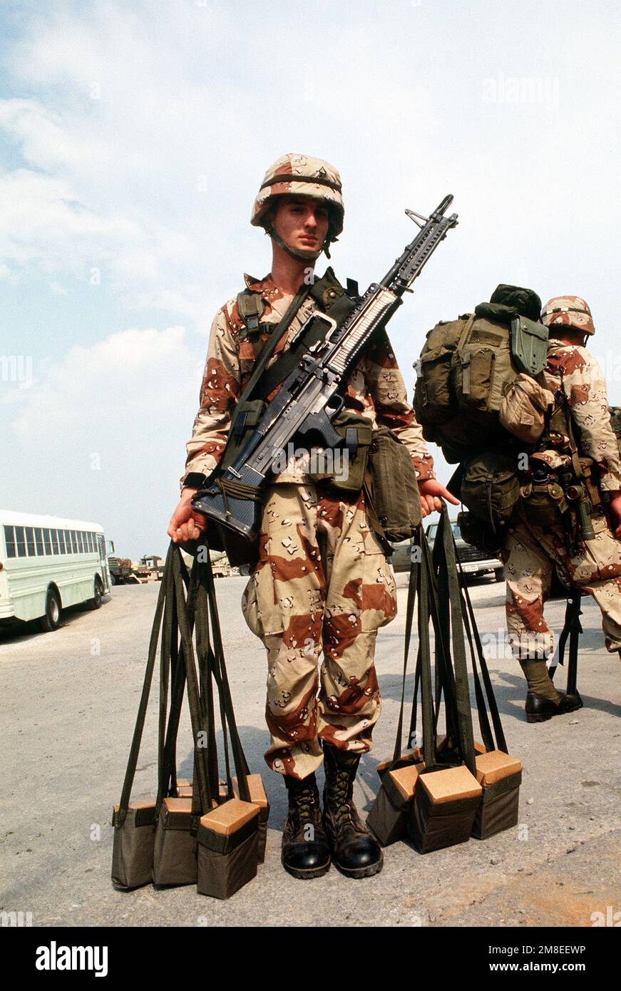 With his M-60 machine gun slung across his chest, a machine gunner with ...