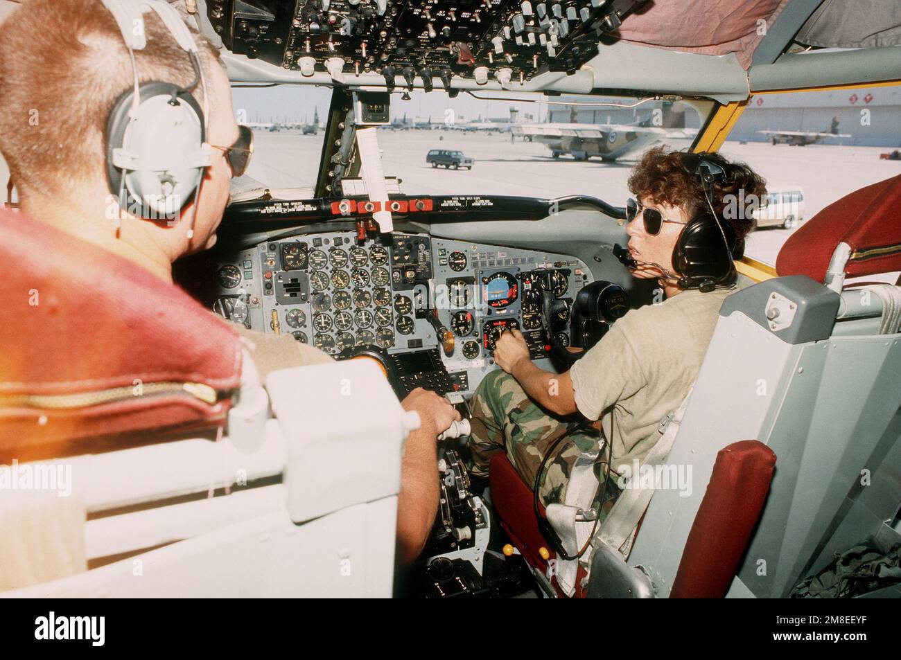 Two ground crew members sit in the cockpit of a KC-135 Stratotanker ...
