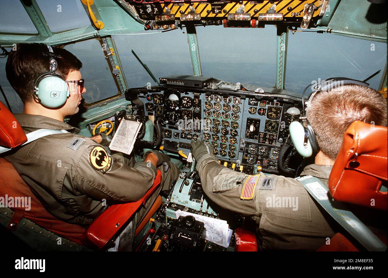 The pilot and co-pilot of a C-130 Hercules aircraft fly their aircraft ...