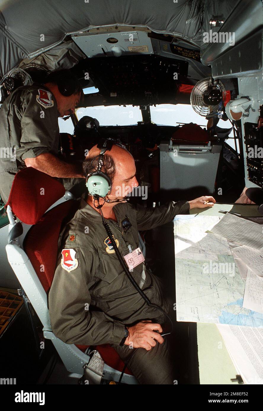A navigator consults a map aboard a KC-135 Stratotanker aircraft as the ...