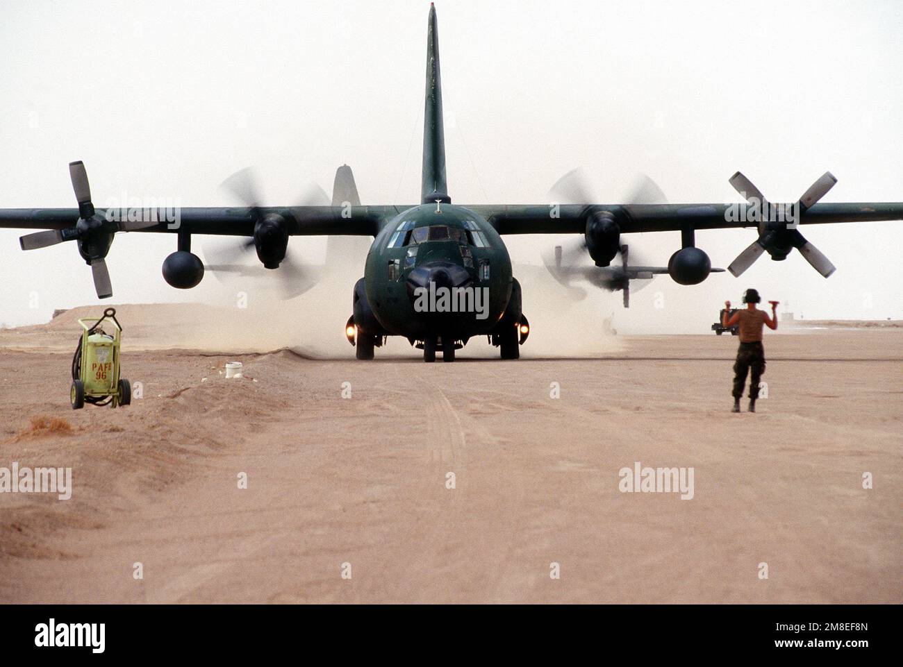 A ground marshal guides a 317th Tactical Airlift Wing C-130 Hercules ...