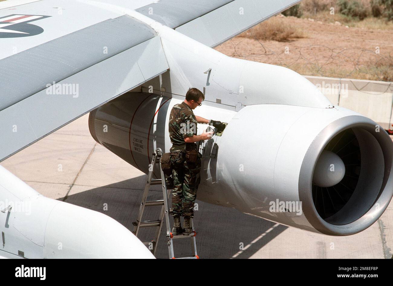A ground crew member checks an engine of a 552nd Airborne Warning and ...