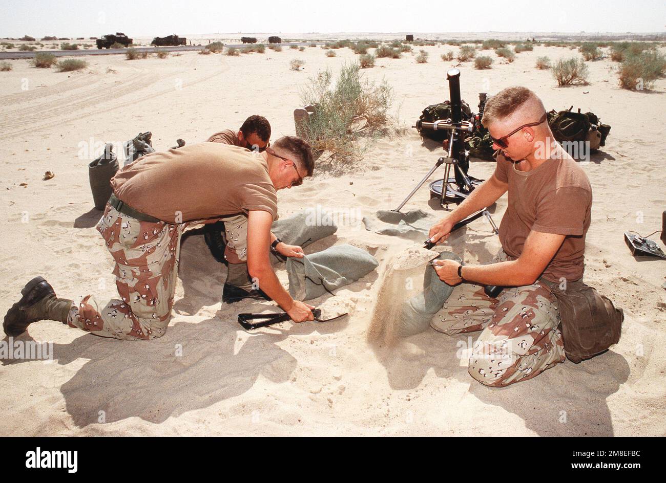 Members of the 82nd Airborne Division fill sand bags as they prepare a ...