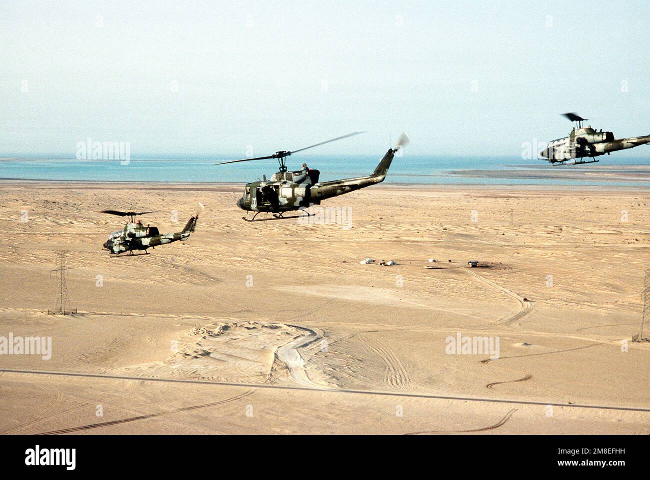 A Marine Corps UH-1N Iroquois helicopter, center, and two AH-1T Sea ...