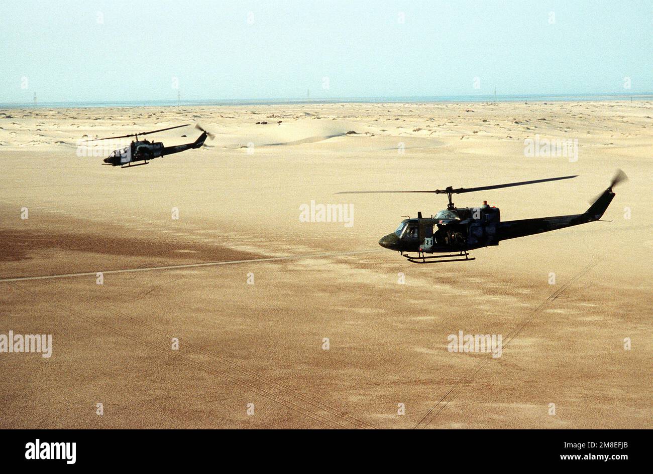 A UH-1N Iroquois helicopter, foreground, and an AH-1 Sea Cobra ...