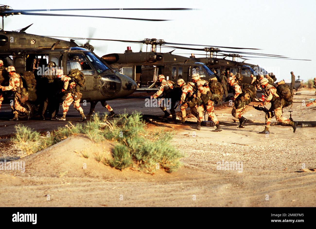Teams of soldiers board several UH-60A Black Hawk (Blackhawk) helicopters during Operation ...