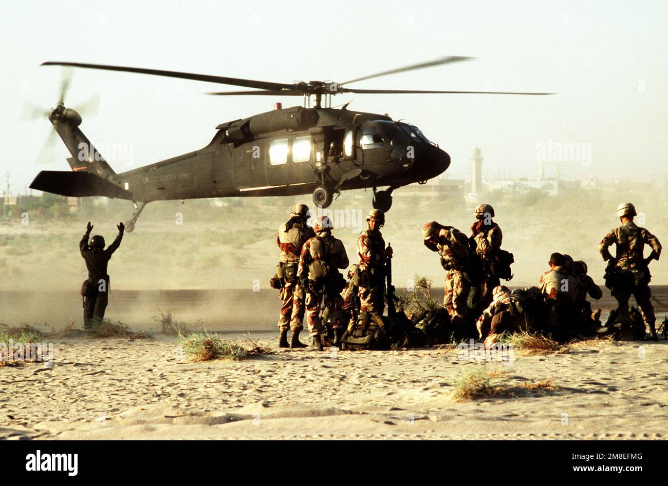 Soldiers stand by to board a UH-60A Black Hawk (Blackhawk) helicopter ...