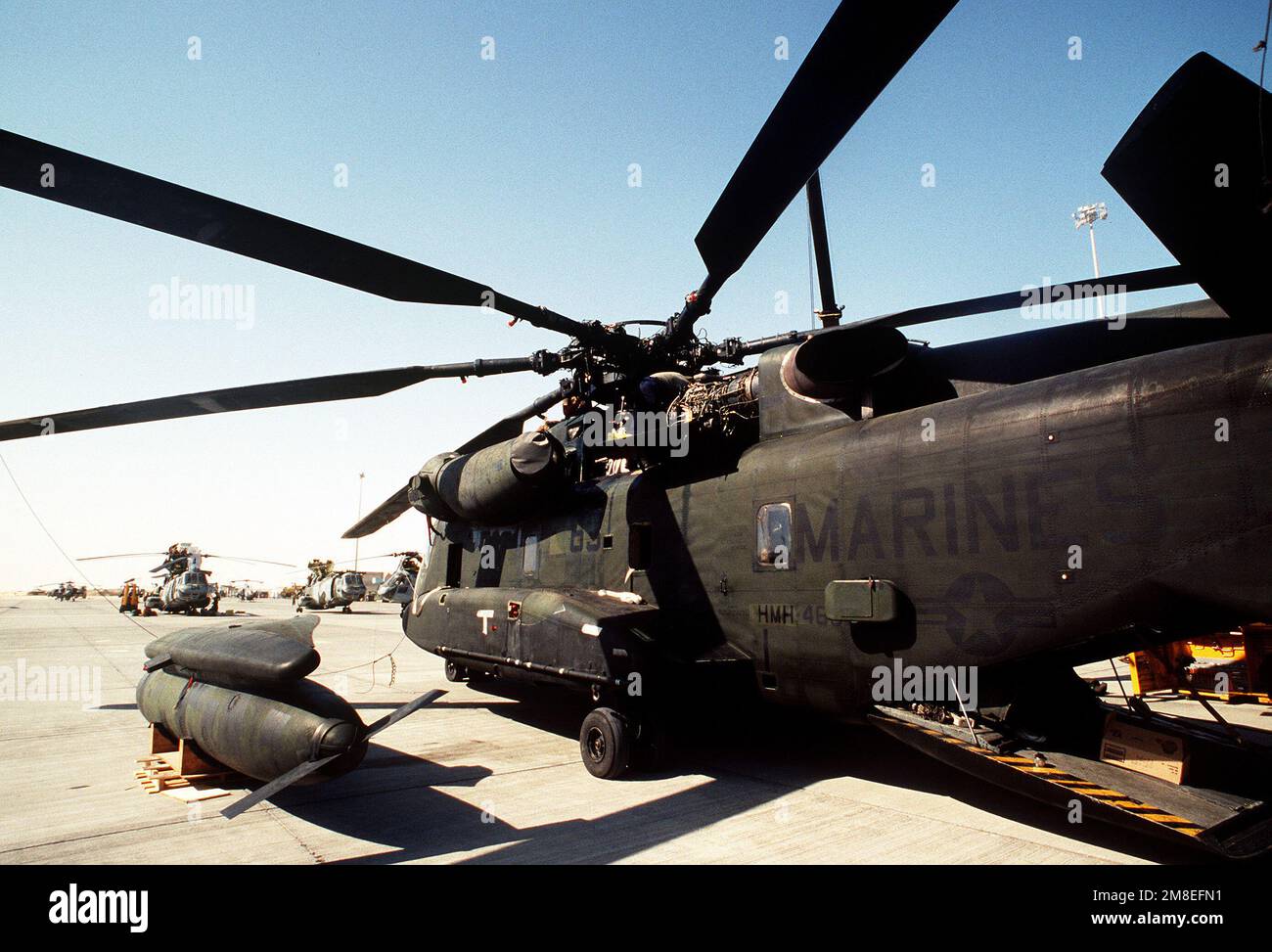 An unattached fuel tank is positioned beside a CH-53E Super Stallion ...