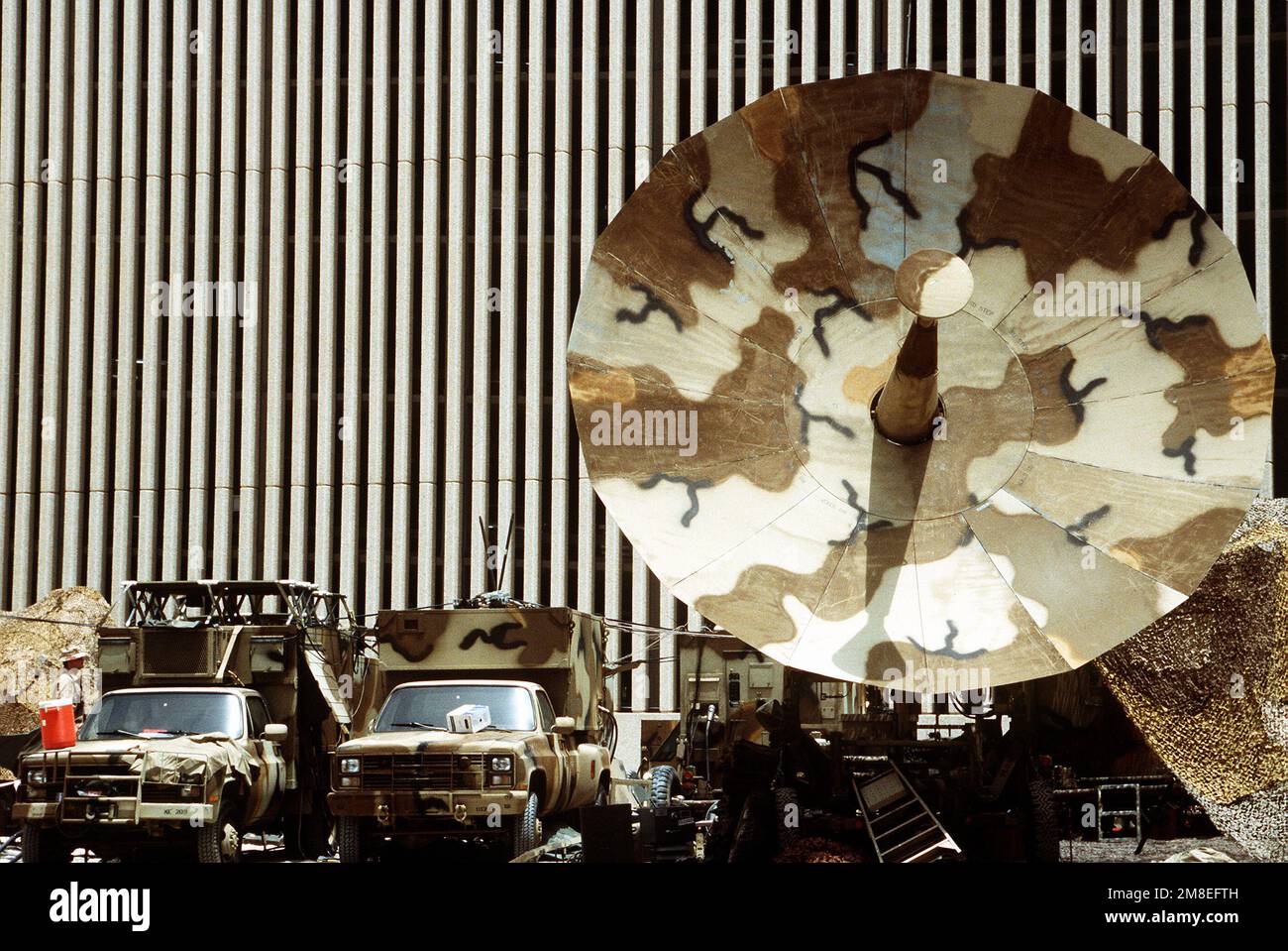 A satellite communications dish stands ready to receive and transmit ...