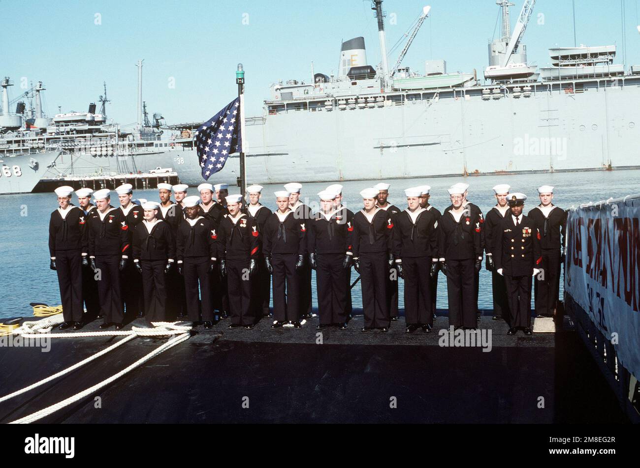 Crew members stand in formation aboard the nuclear-powered attack ...